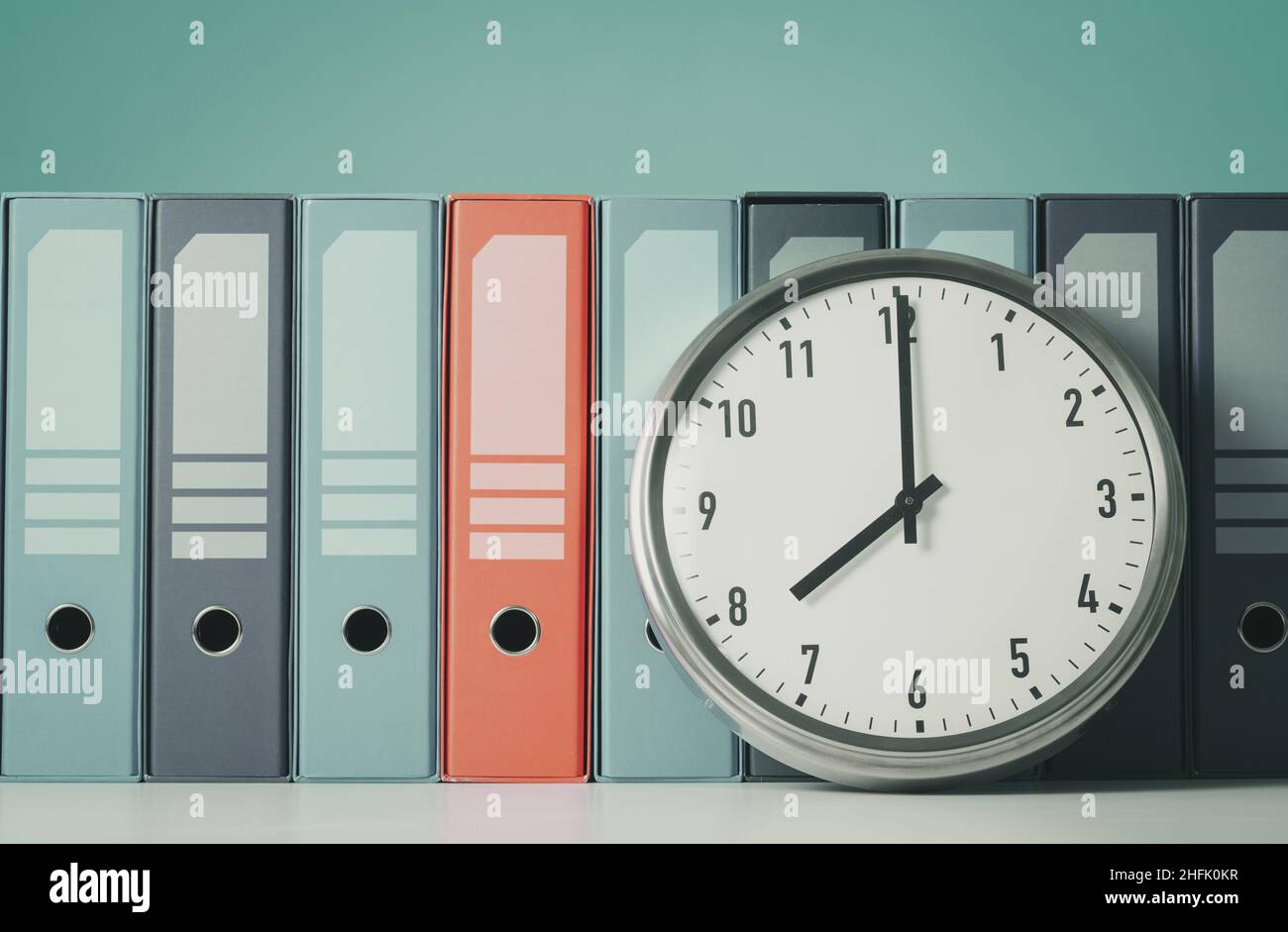 Ring binders and clock: business deadlines and time management concept ...