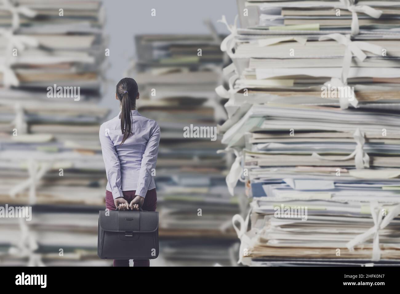 Frustrated lost businesswoman staring at huge piles of paperwork, work ...