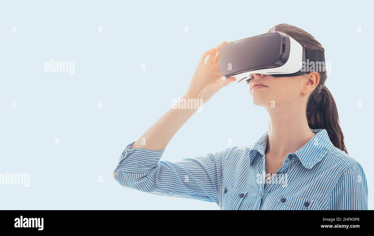 Young woman experiencing virtual reality, she is wearing a VR headset ...