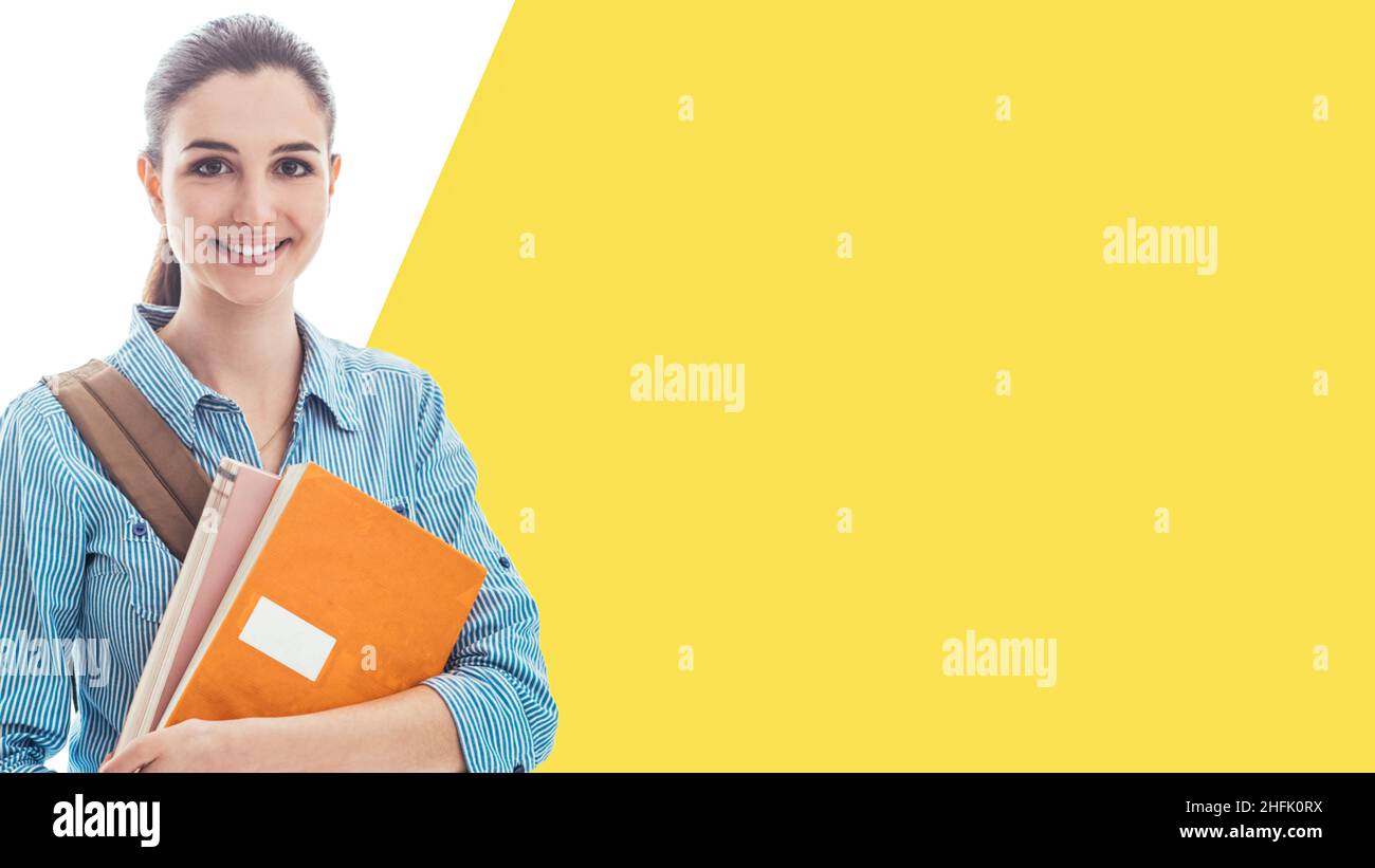 Young female college student portrait, she is smiling at camera and ...