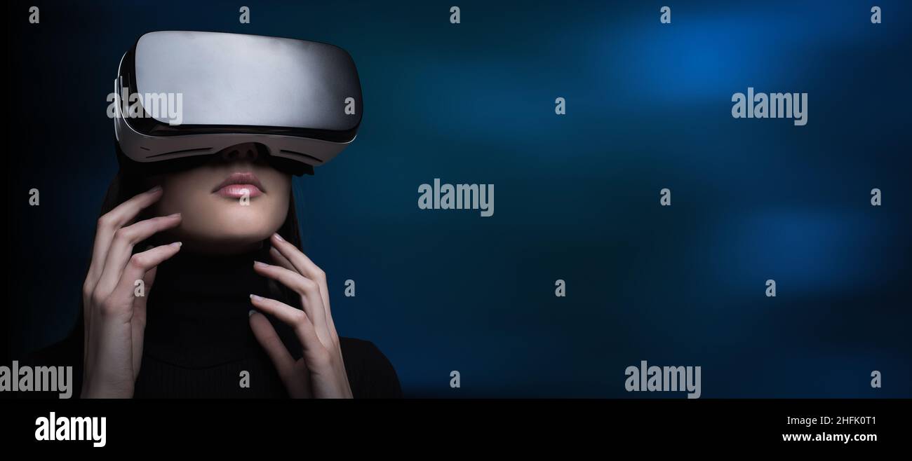 Young beautiful woman wearing a VR headset and experiencing a virtual ...