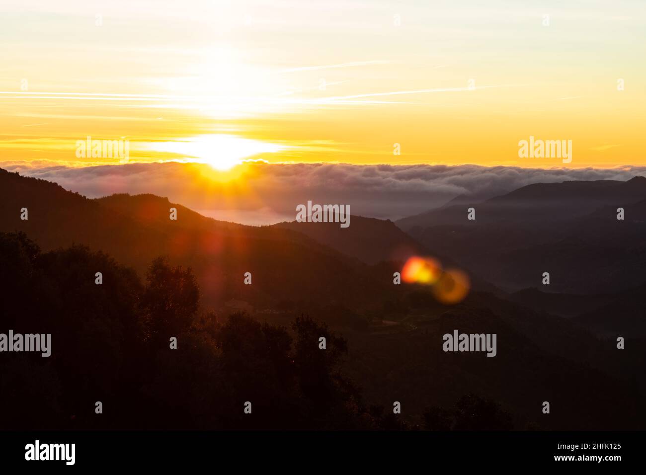 Orange sun rising over clouds view from the top of Montseny mountain ...