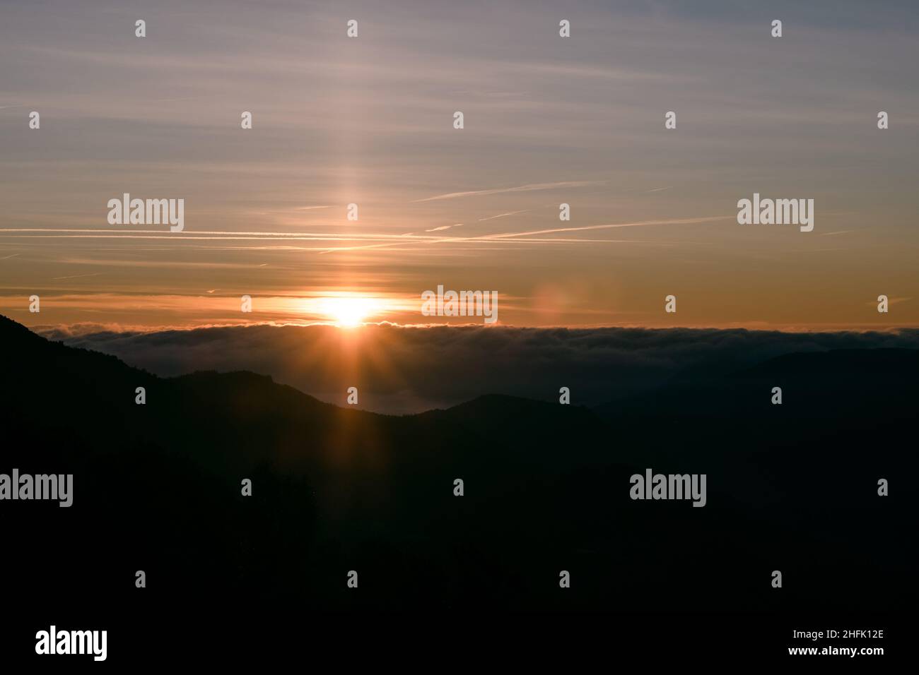Orange sun rising over clouds view from the top of Montseny mountain ...