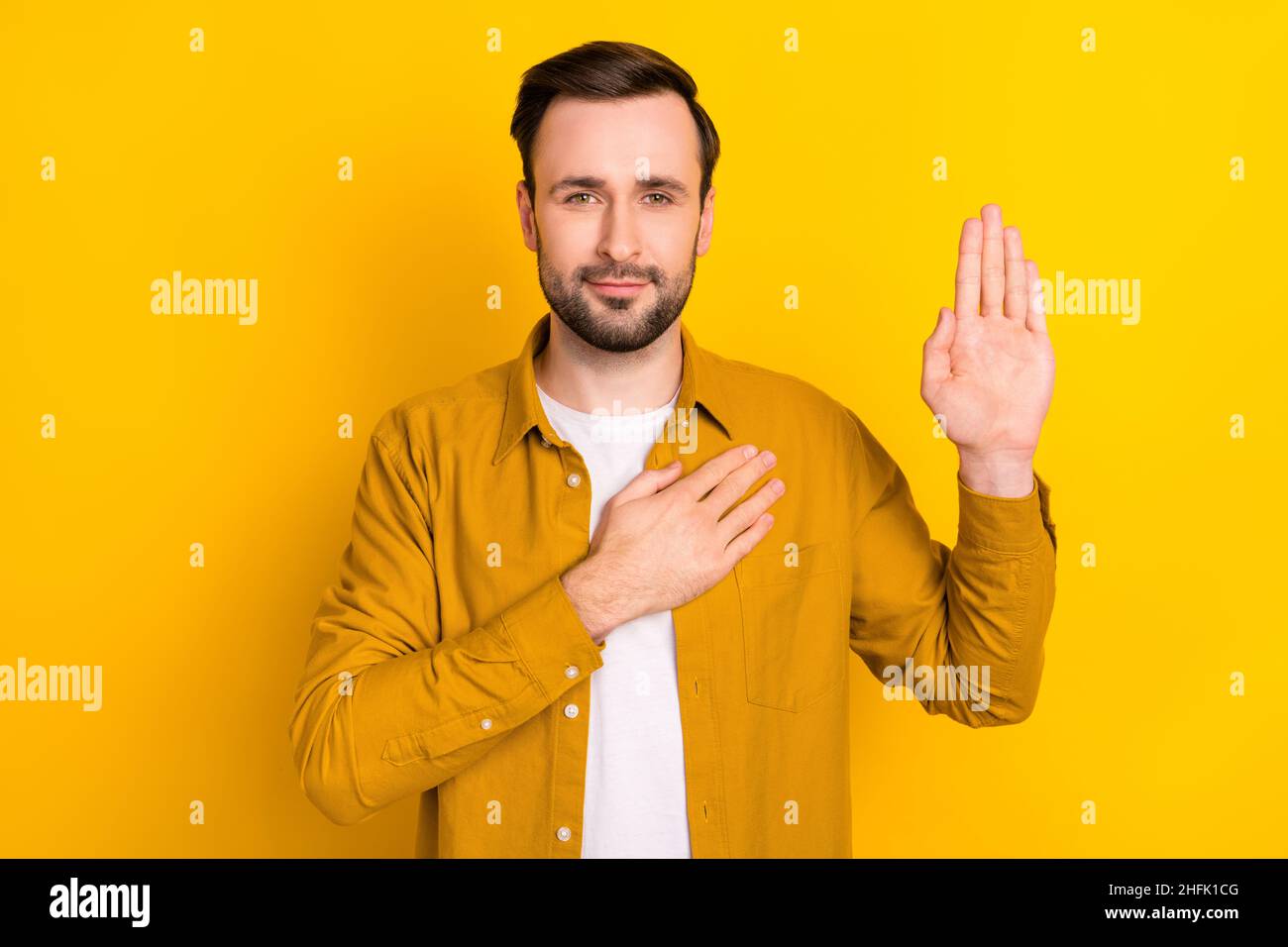 Photo of young man hands on chest make oath swear tell truth justice ...