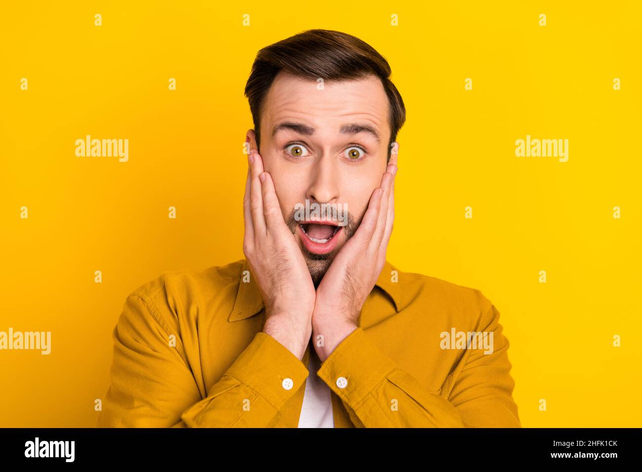 Photo of young handsome man amazed shocked surprised hands touch cheeks ...