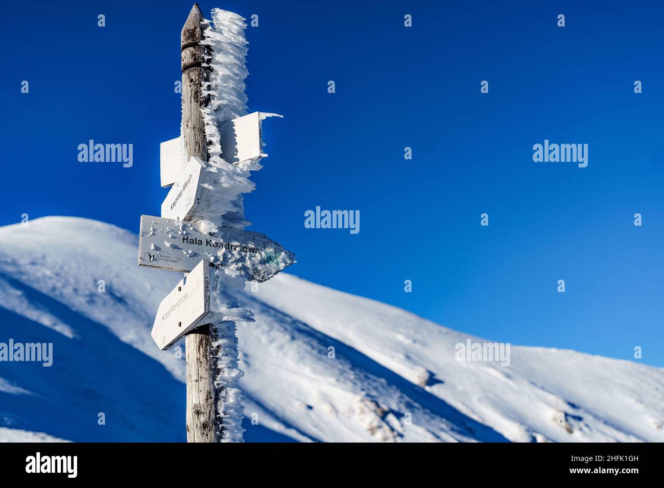 Frozen and ice-covered hiking trail markings in high snowy mountains ...