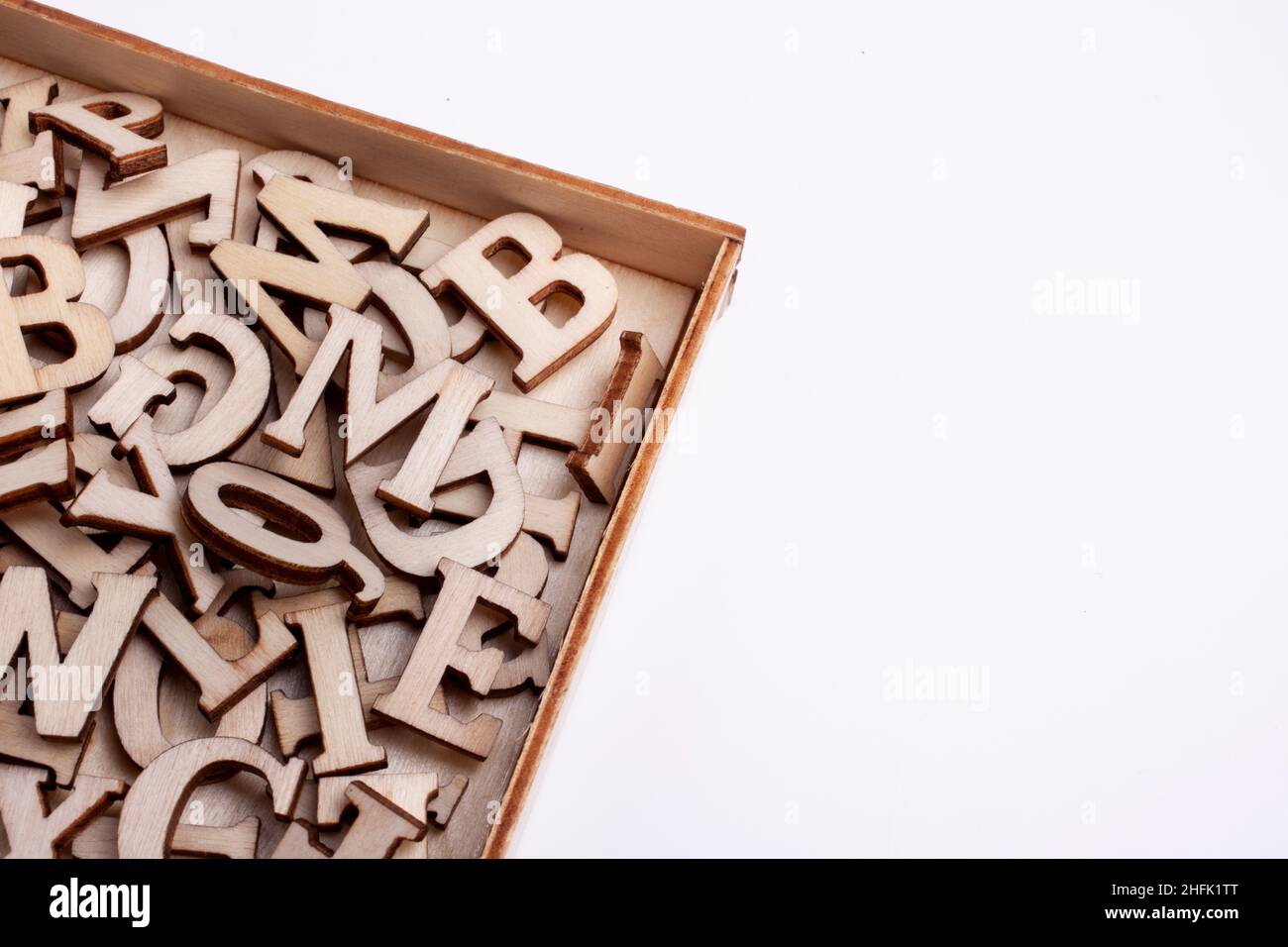 Random Wooden Letters in a box with white background - copy space Stock ...