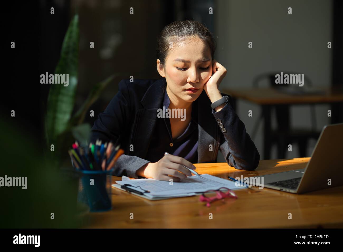 Sleepy and bored businesswoman sitting at her office desk and working ...