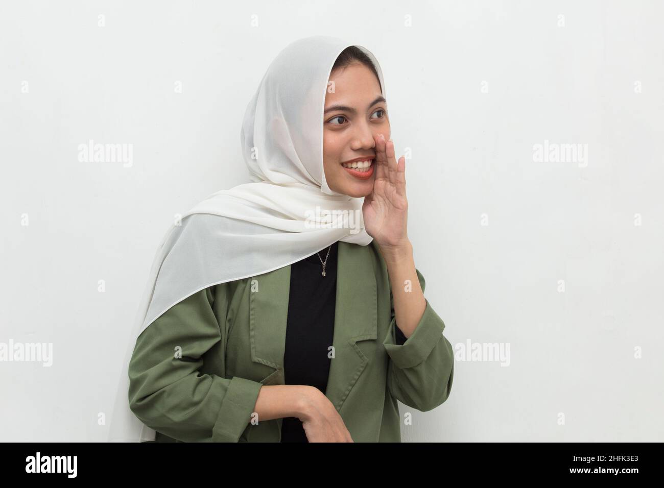 Portrait of young Asian muslim woman announcement shouting and yelling ...