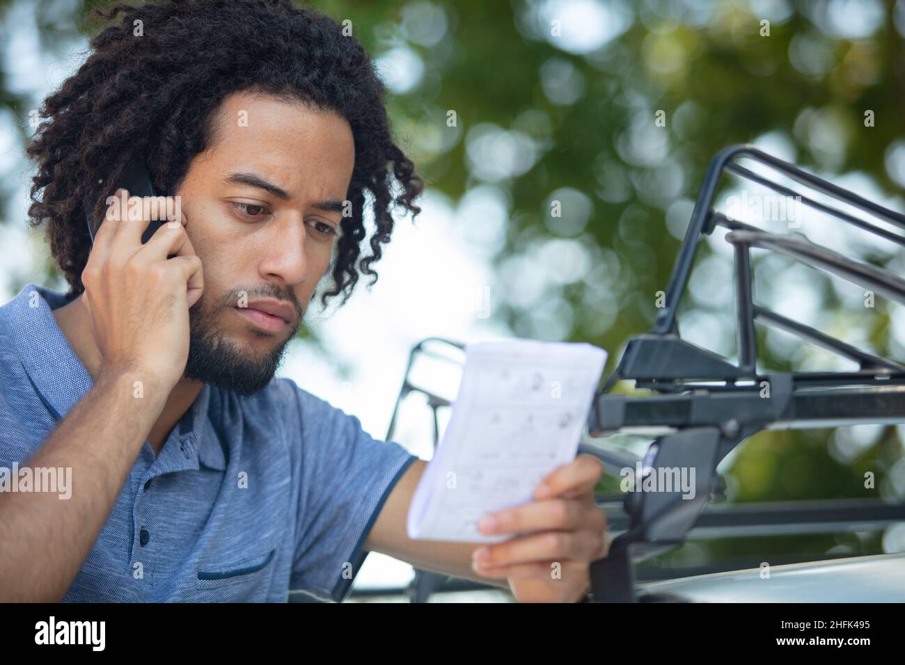 man reading instructions for securing a vehicle roof rack Stock Photo ...