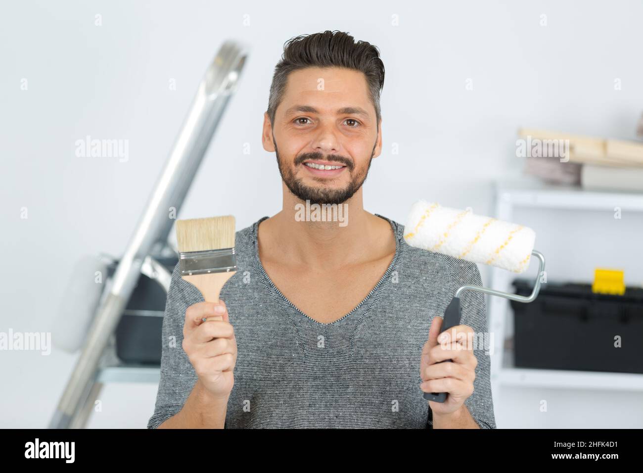 handsome painter holding a paint roller Stock Photo - Alamy