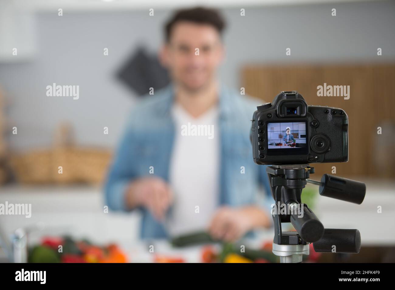 man shooting video of himself using camera on tripod Stock Photo - Alamy