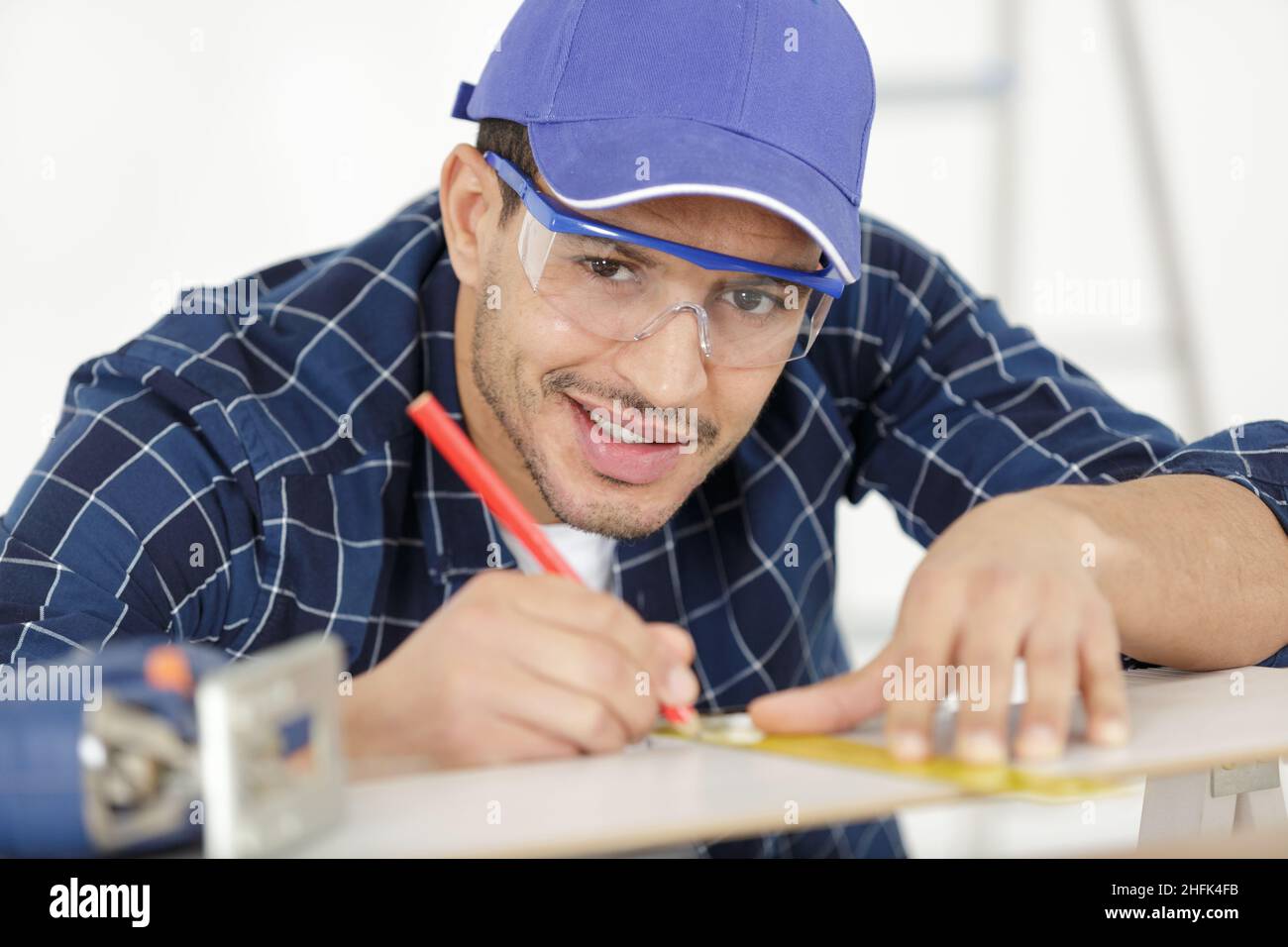 male contractor measuring materials with ruler Stock Photo - Alamy