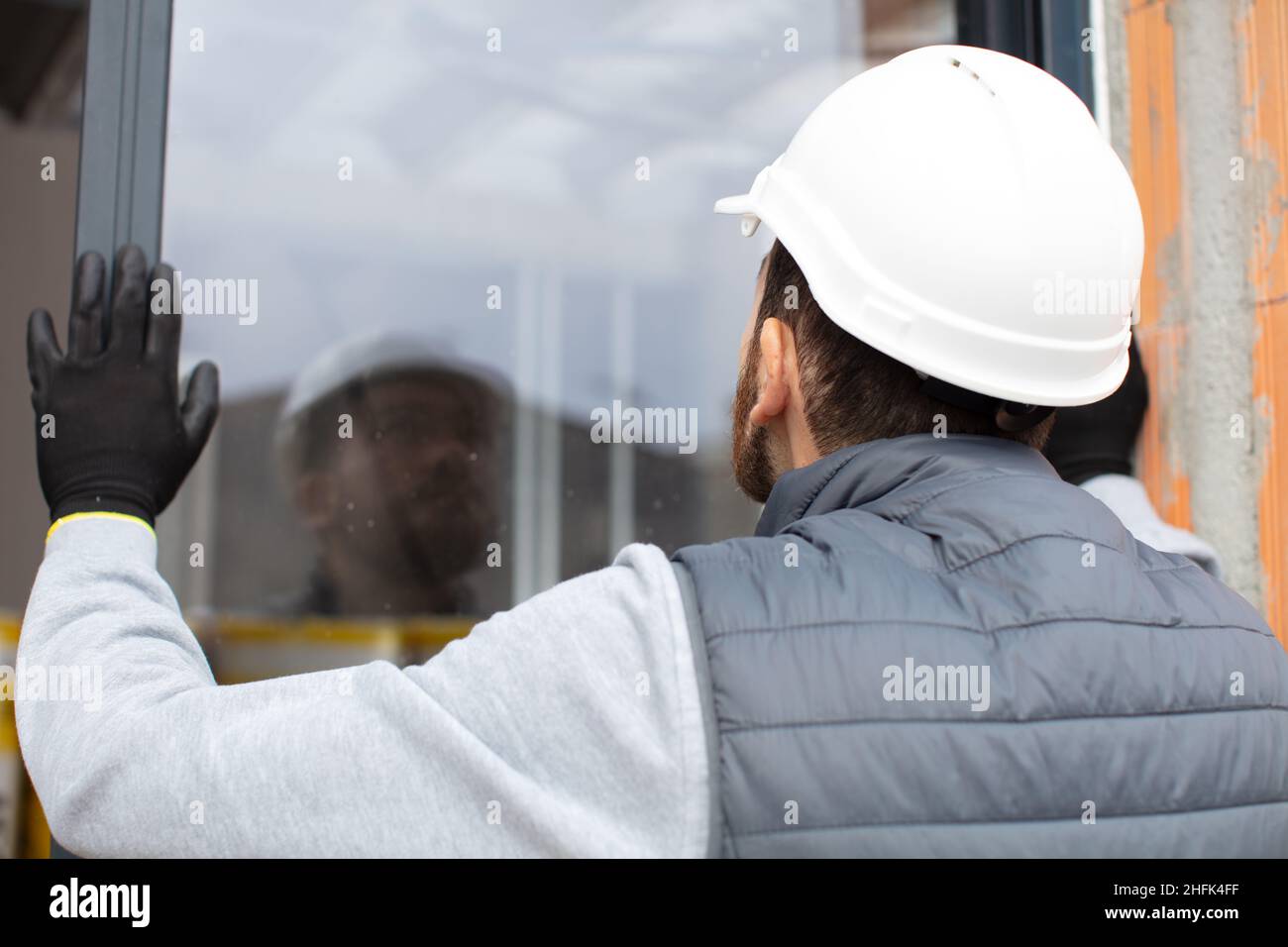 rear view of worker installing upvc window Stock Photo - Alamy