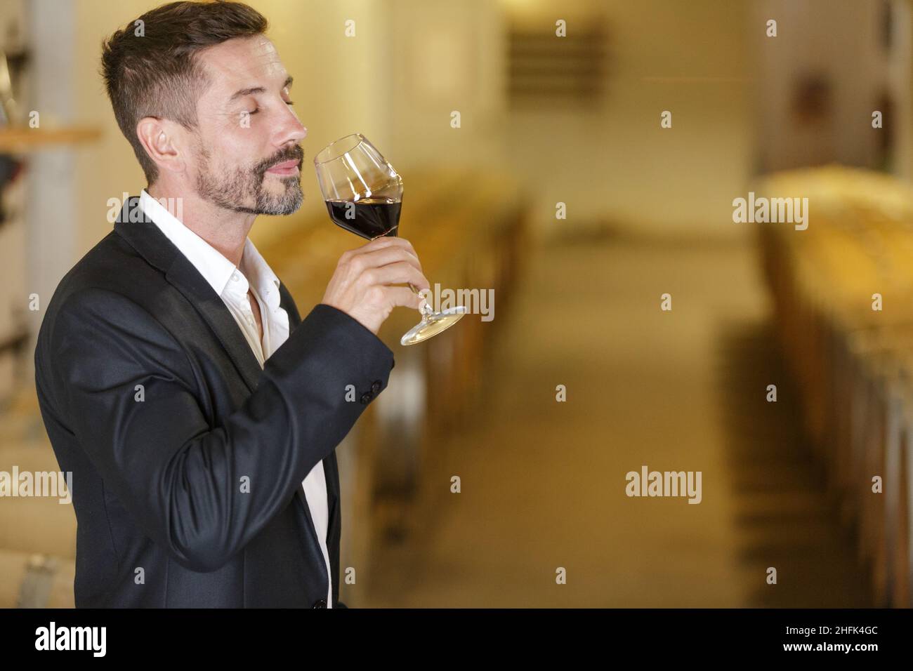 male doine a wine tasting contest in a cellar Stock Photo - Alamy
