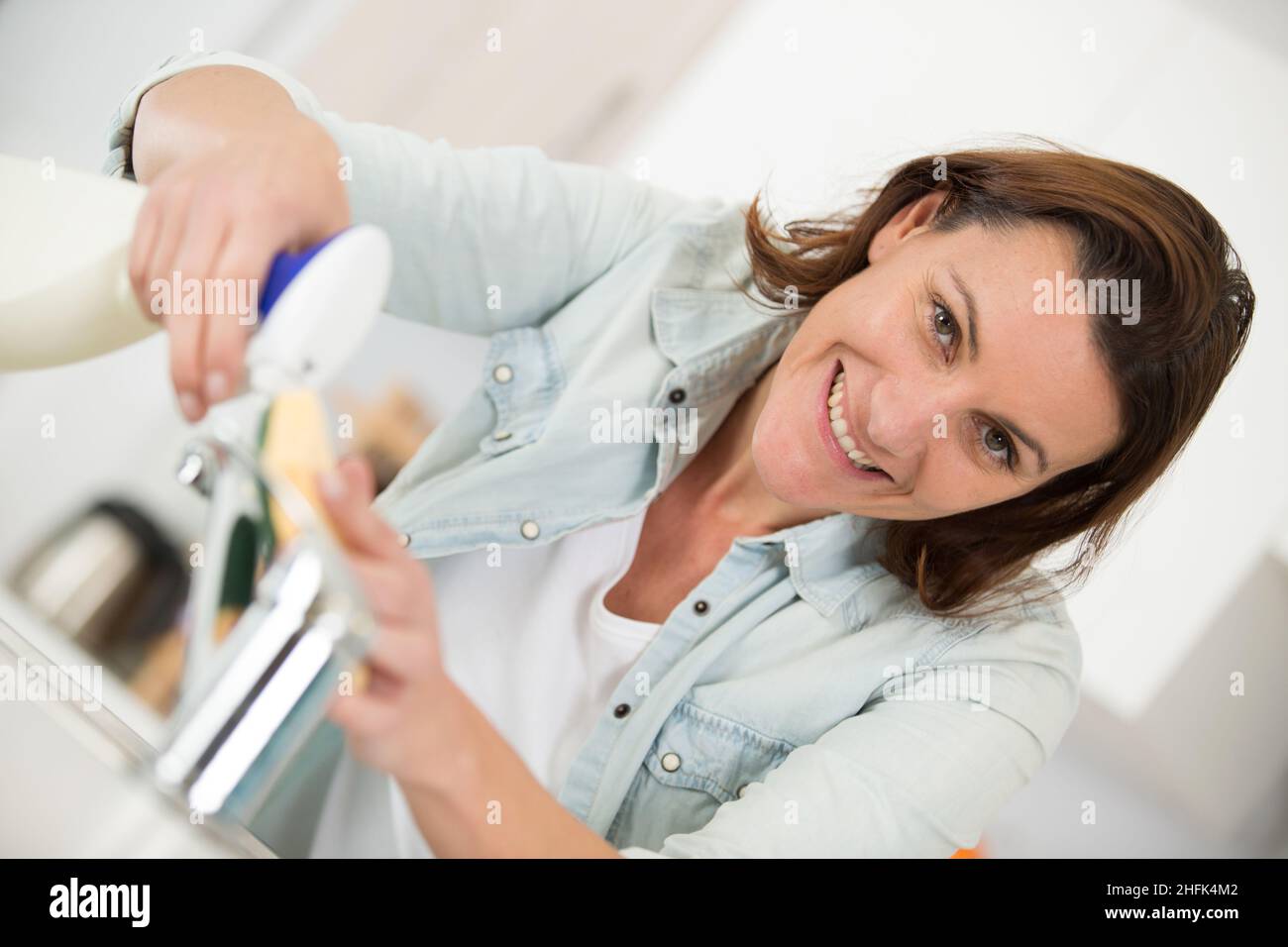 woman scrubbing the kitchen counter with a sponge Stock Photo - Alamy