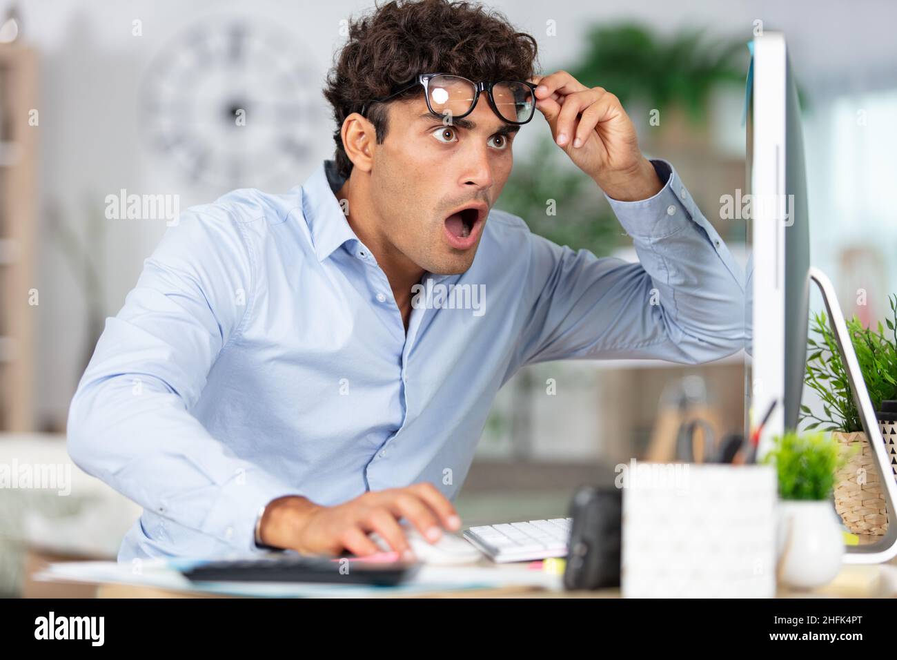 man shocked reading message on computer in office Stock Photo - Alamy