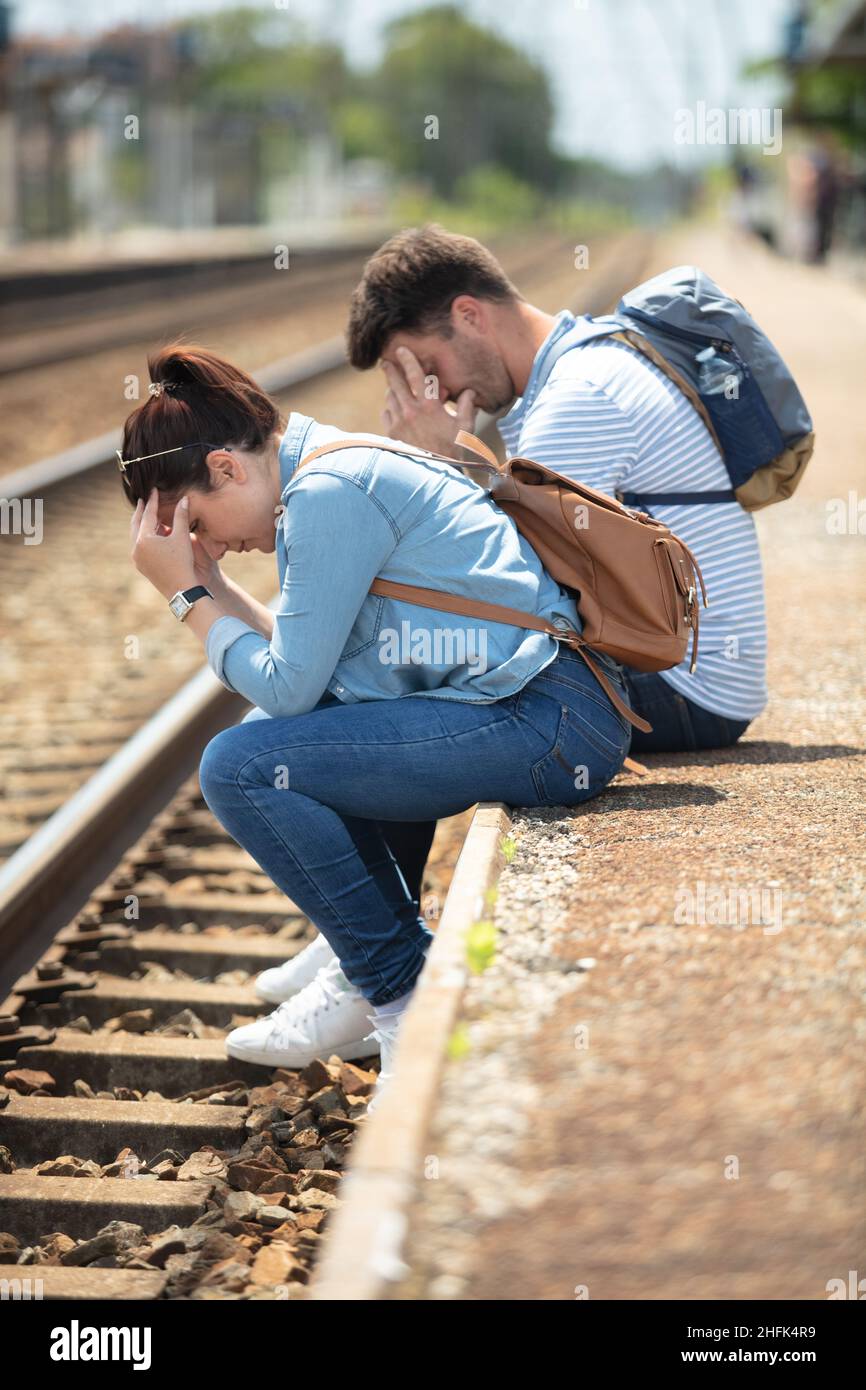 upset couple at railway station wiring for train Stock Photo - Alamy