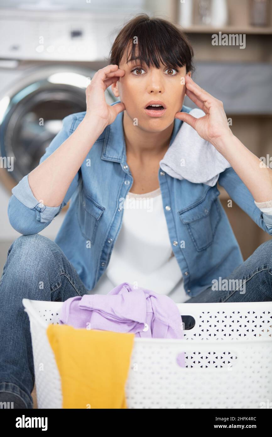woman with shocked expression sat by a laundry basket Stock Photo - Alamy