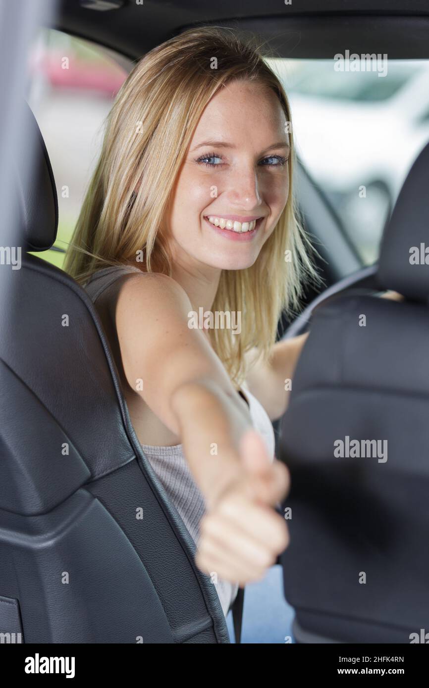 happy woman inside a car with thumb up Stock Photo - Alamy