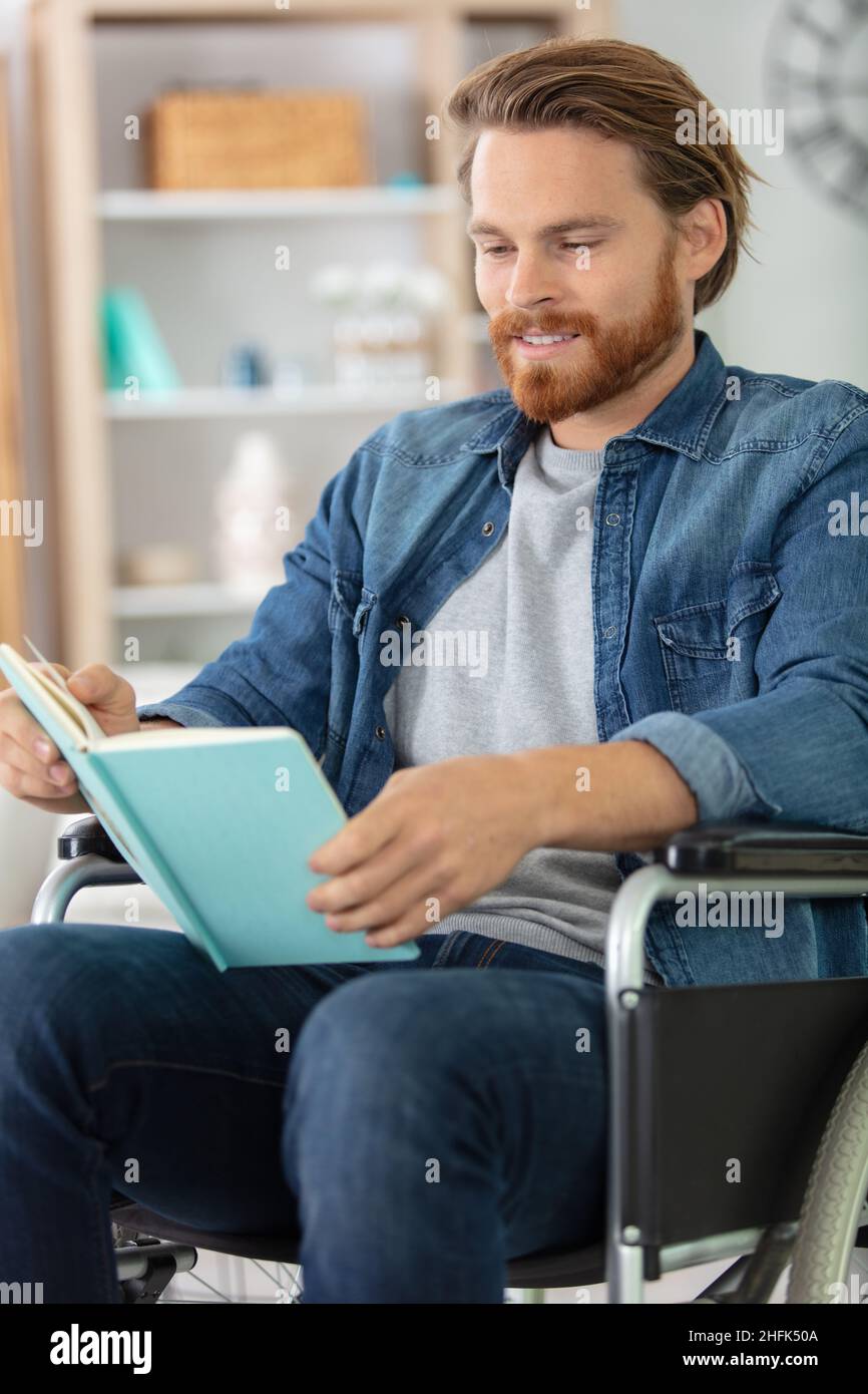 smart disabled guy reading during breakfast Stock Photo - Alamy
