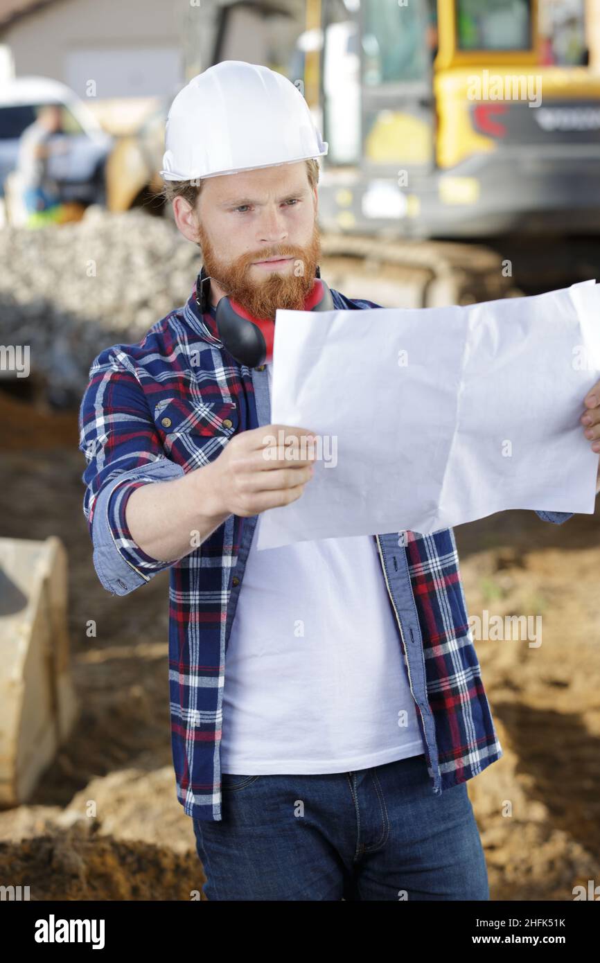 engineer looking at plan in scrapyard Stock Photo - Alamy