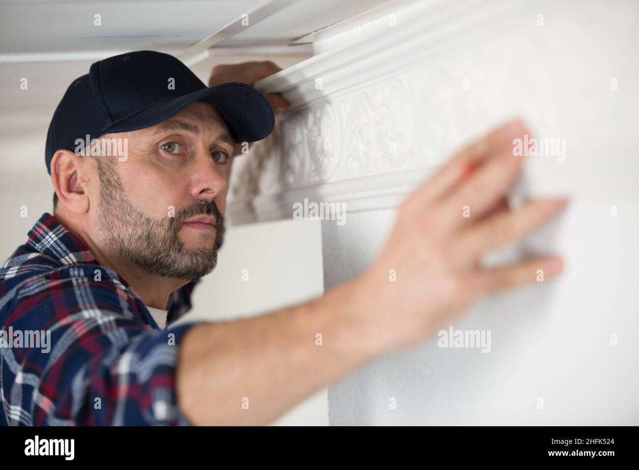 male decorator working on ceiling cornice Stock Photo - Alamy