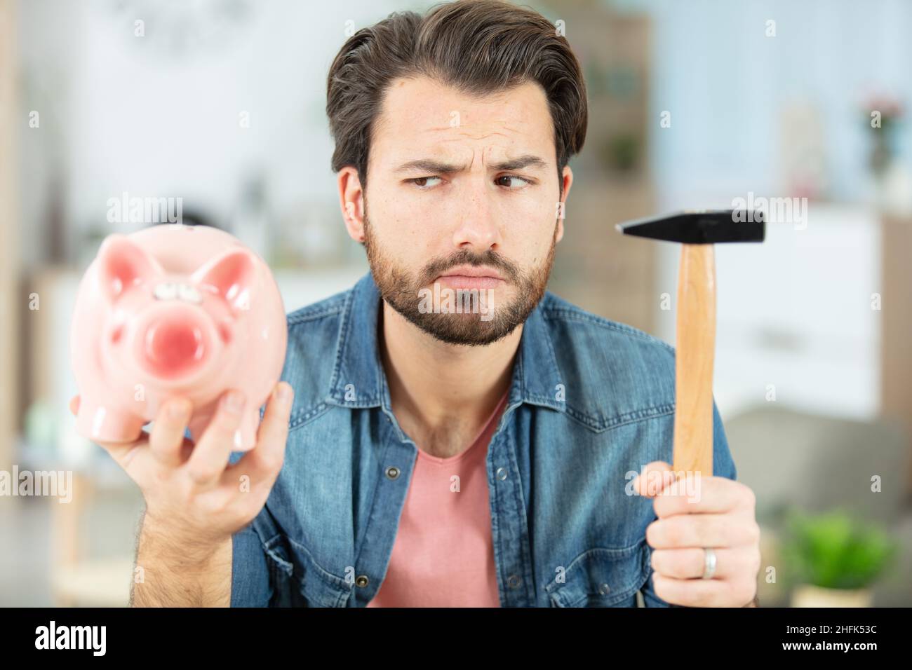 young man is breaking piggy money bank Stock Photo - Alamy