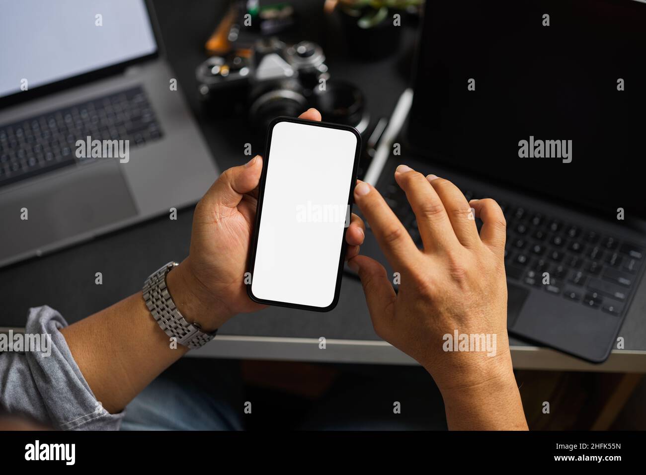 Close-up image of an adult man holding a smartphone blank screen mockup ...
