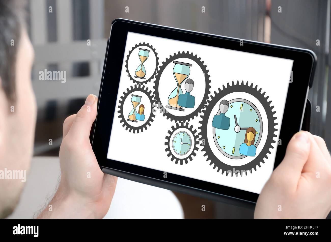 Man holding a tablet showing time management concept Stock Photo - Alamy