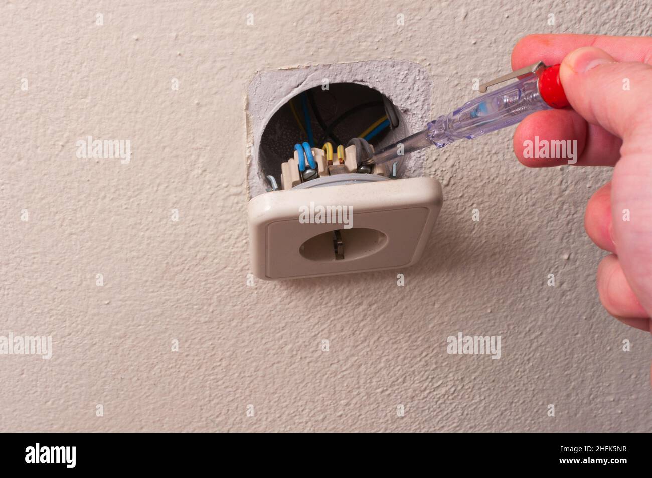 repair of electrical socket on the wall, with the aid of a phase finder ...