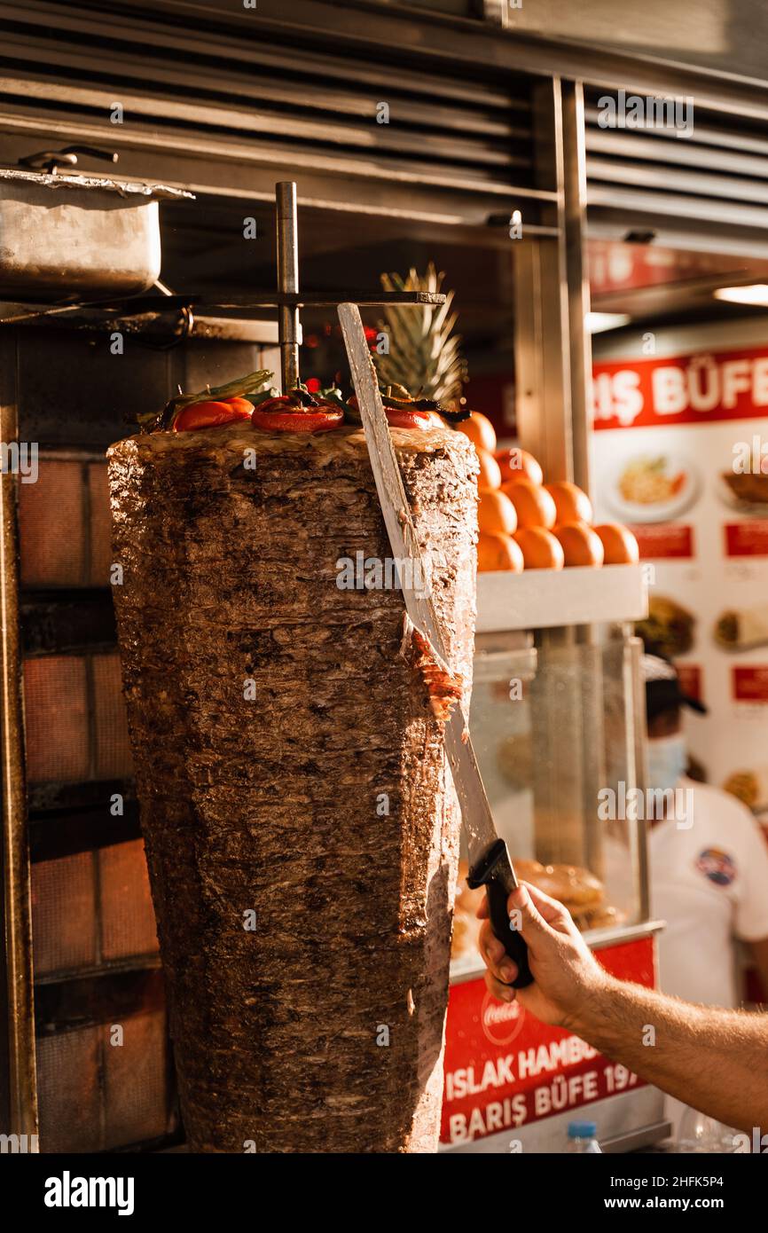 Cutting beef and lamb on a split for cooking doner kebab. Process of ...
