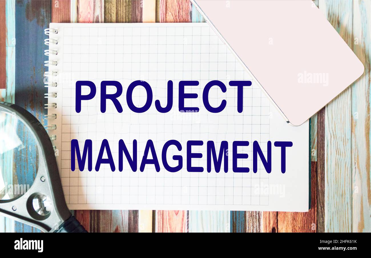 Project management memo written on a notebook with pen Stock Photo - Alamy