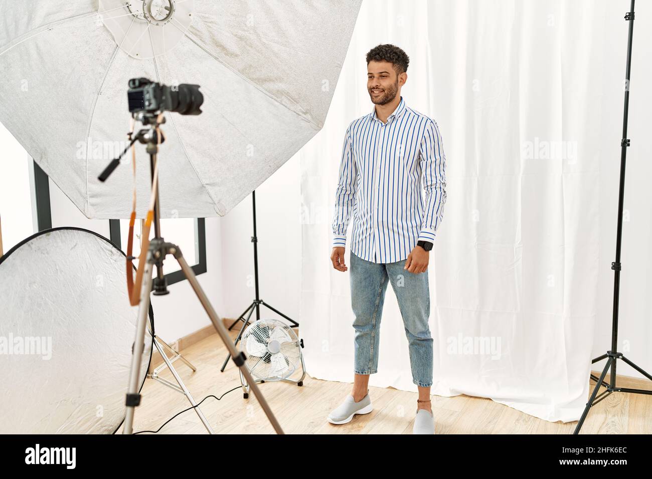 Arab young man posing as model at photography studio with a happy and ...