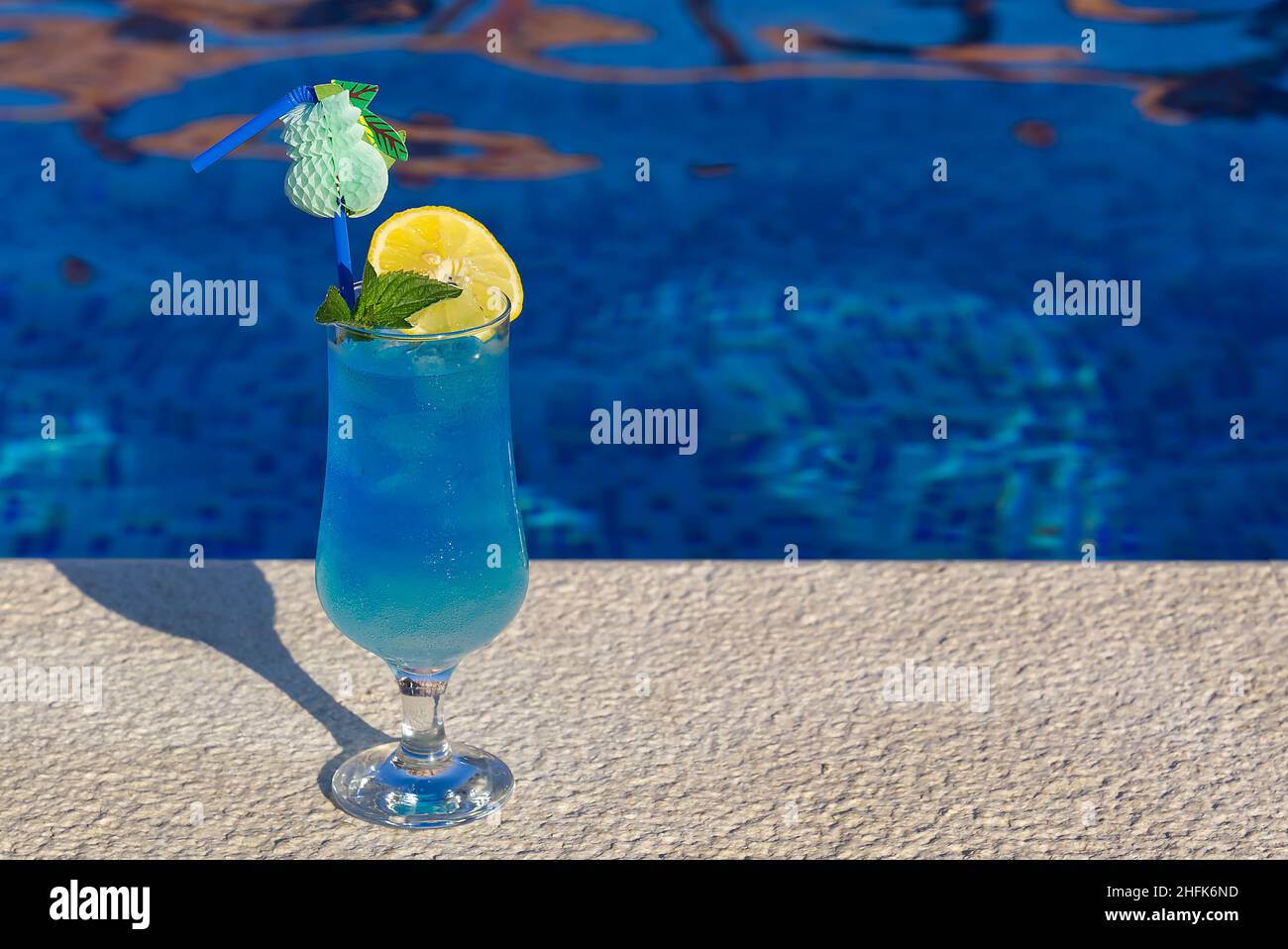 Blue Lagoon Beach Cocktail with fresh lemon standing by the swimming ...