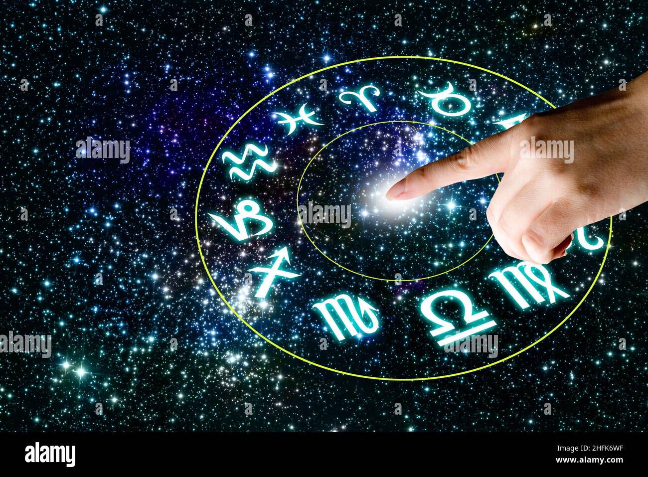 hand touching an astrology wheel in space, with all sign of the zodiac ...