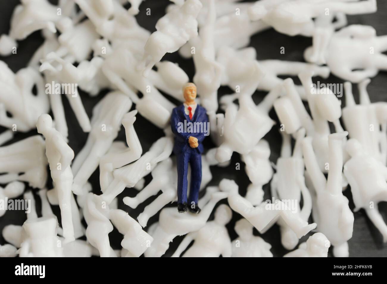 blank molded plastic miniature figurines with one painted, standing out ...