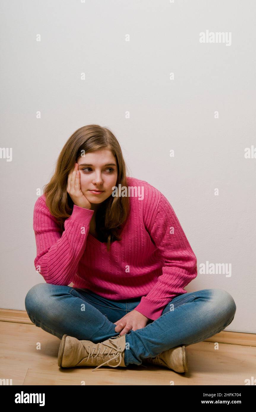 tween light brown haired girl sitting pensive on the floor Stock Photo ...