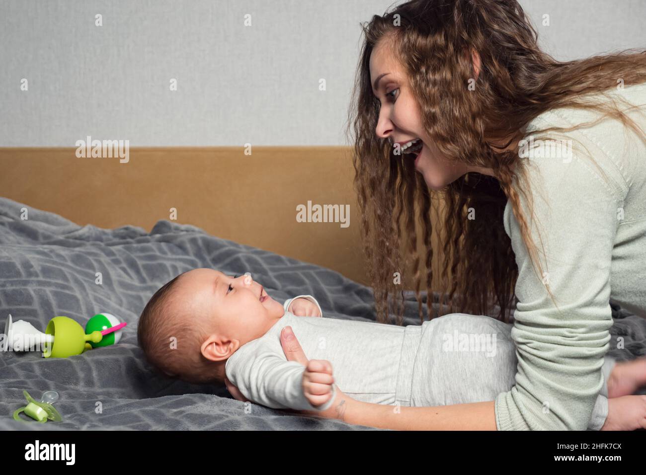 young mom with baby have fun on the bed Stock Photo - Alamy