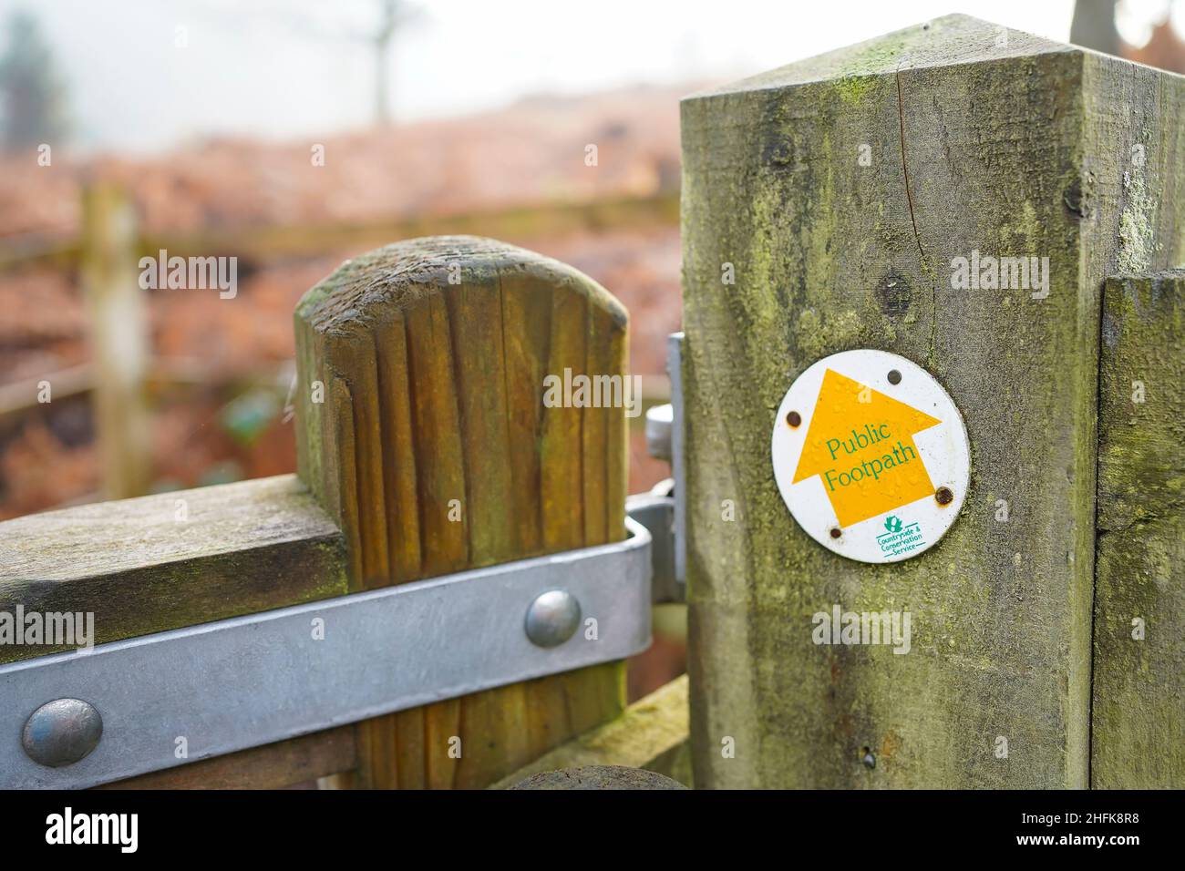 Public footpath sign on a gatepost in rural UK countryside, on a winter ...