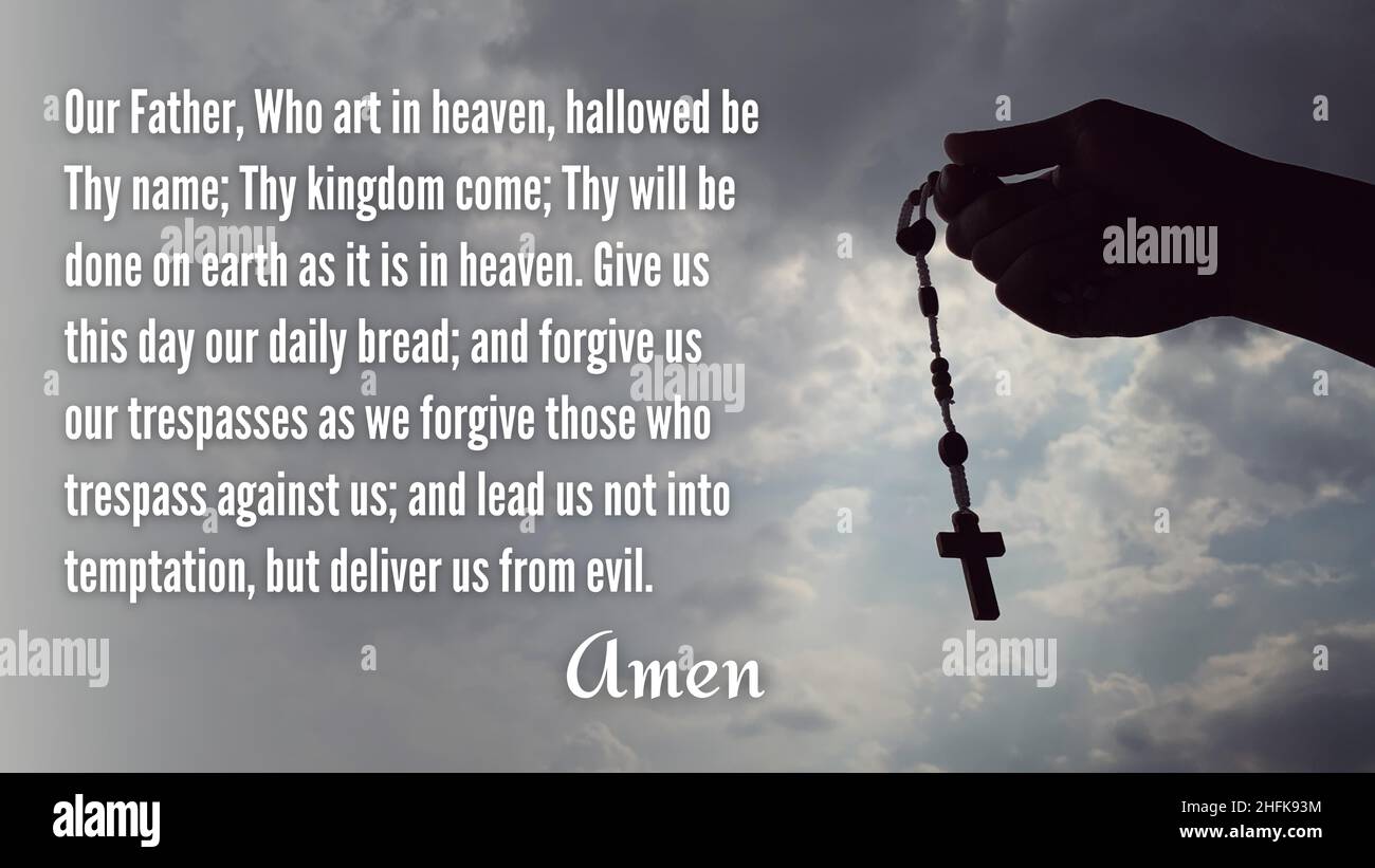 Christian prayer of Our Father with hand holding Rosary and sky ...
