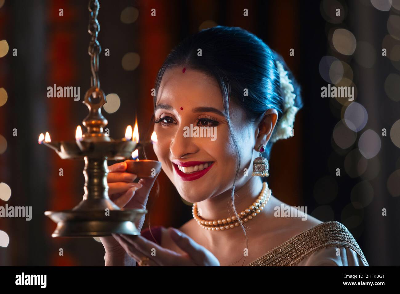 Beautiful Indian wonam lightning a lamp with diya on the occasion of ...