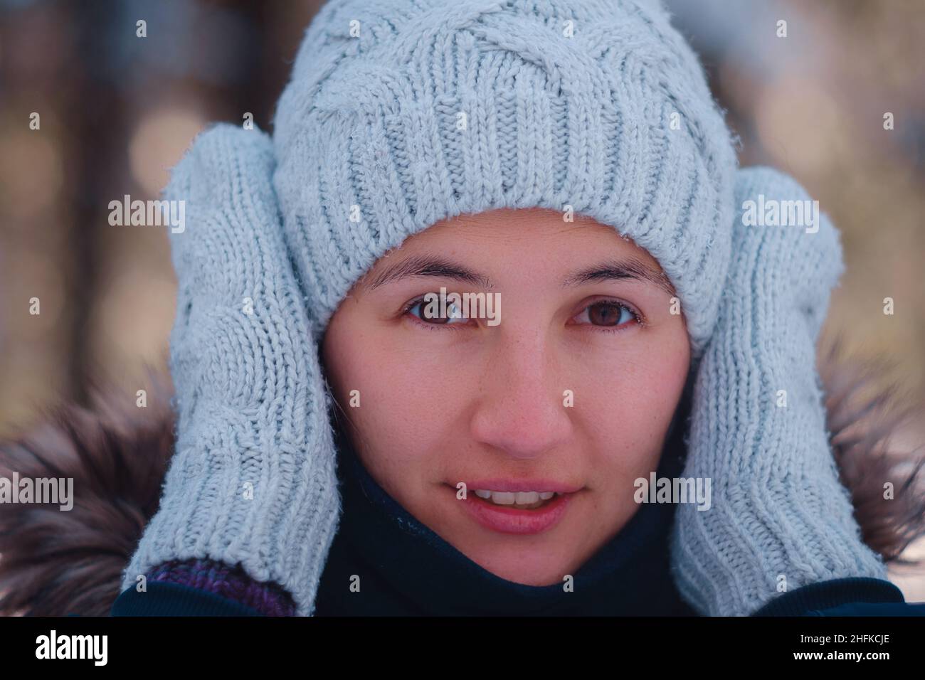 Happy Asian woman walking in winter snow forest. Cold weather hat and ...