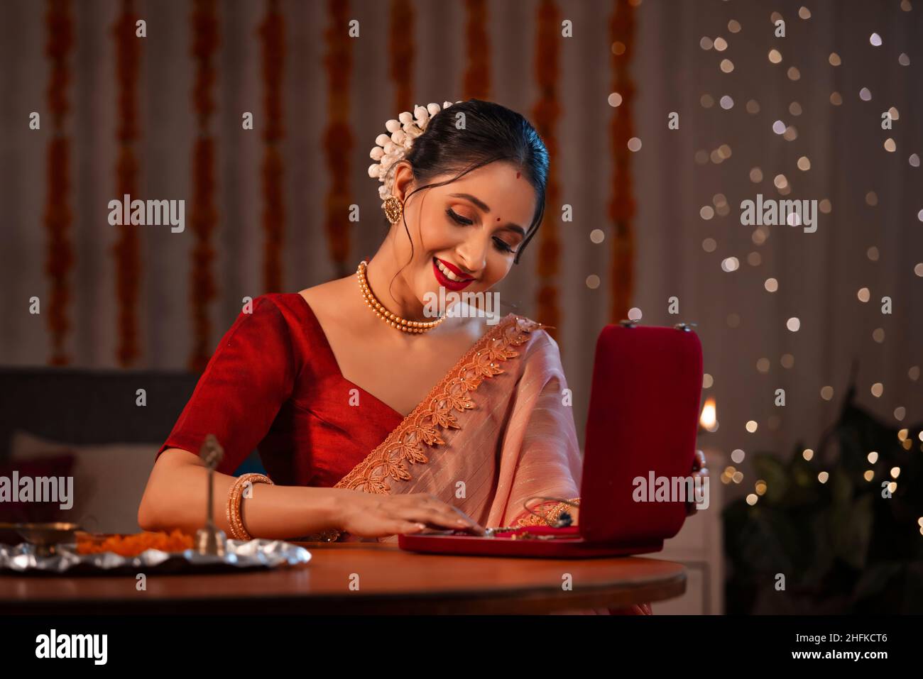 A beautiful woman touching the ornament in gold jewellery box amidst ...