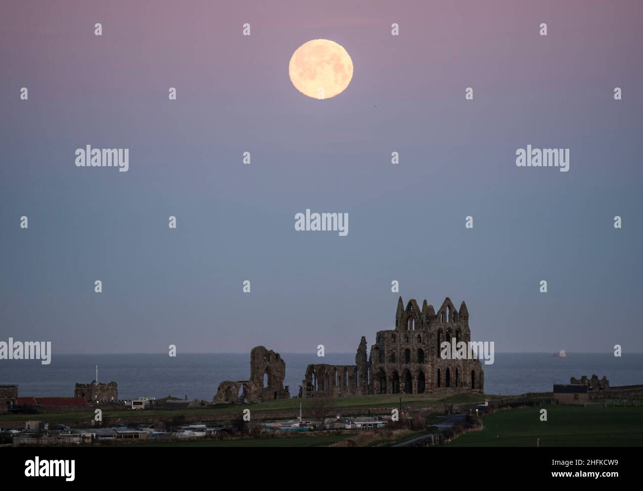 The moon sets behind Whitby Abbey in Yorkshire. The first full moon of ...