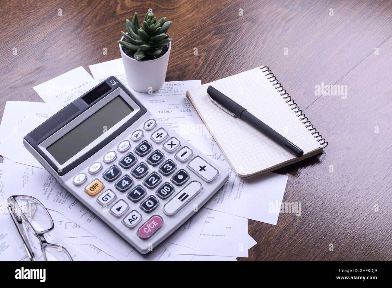 Calculator keypad with checks from the store from shopping on a wooden ...