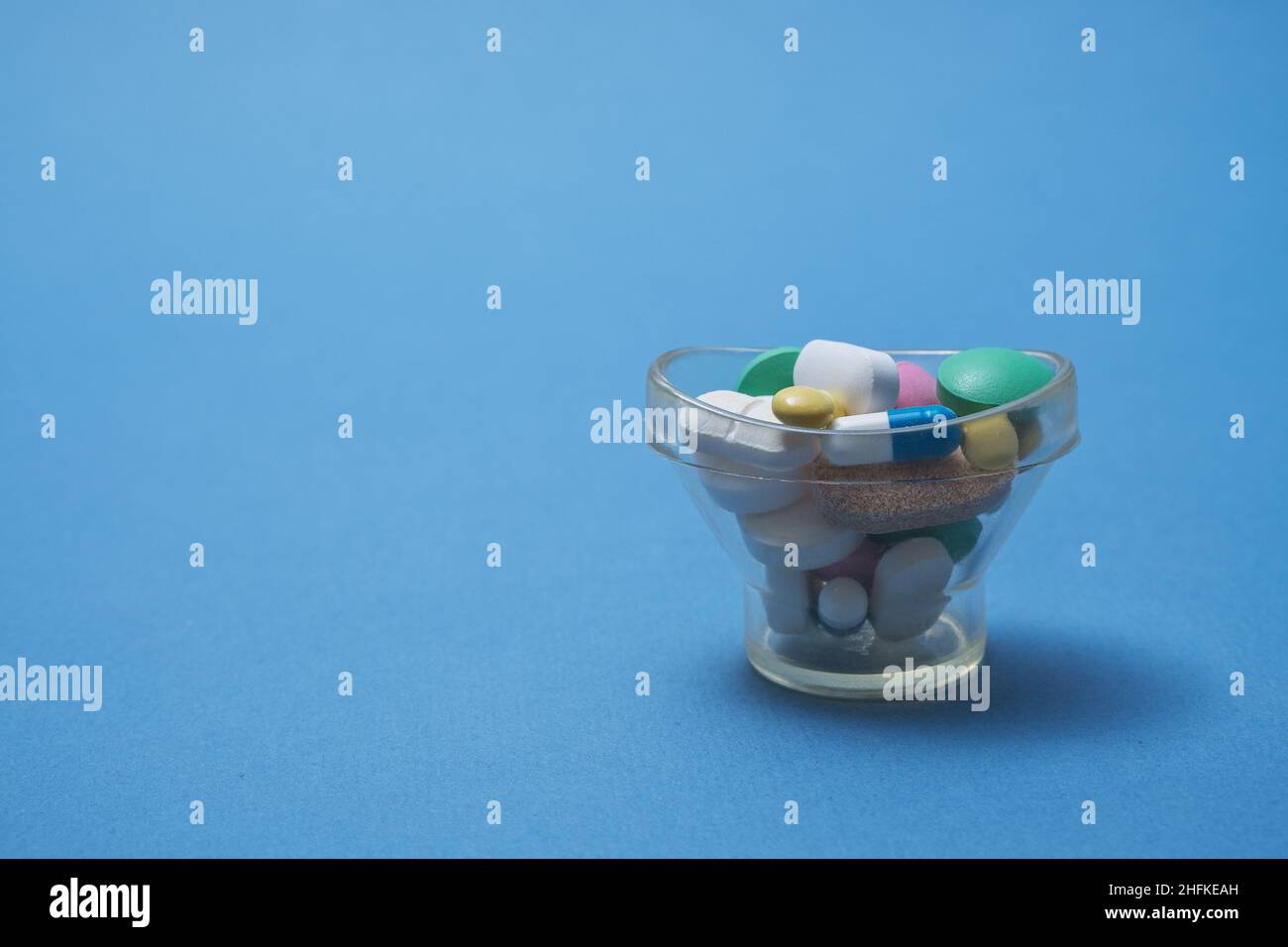 Medical cup with medicines on a blue background Stock Photo - Alamy