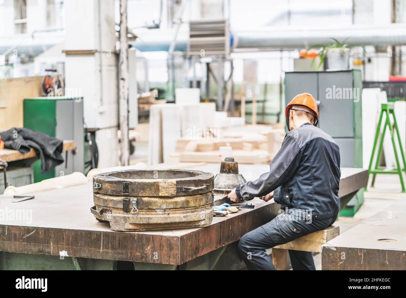 Worker in yellow hard hat and uniform in factory interior Stock Photo ...