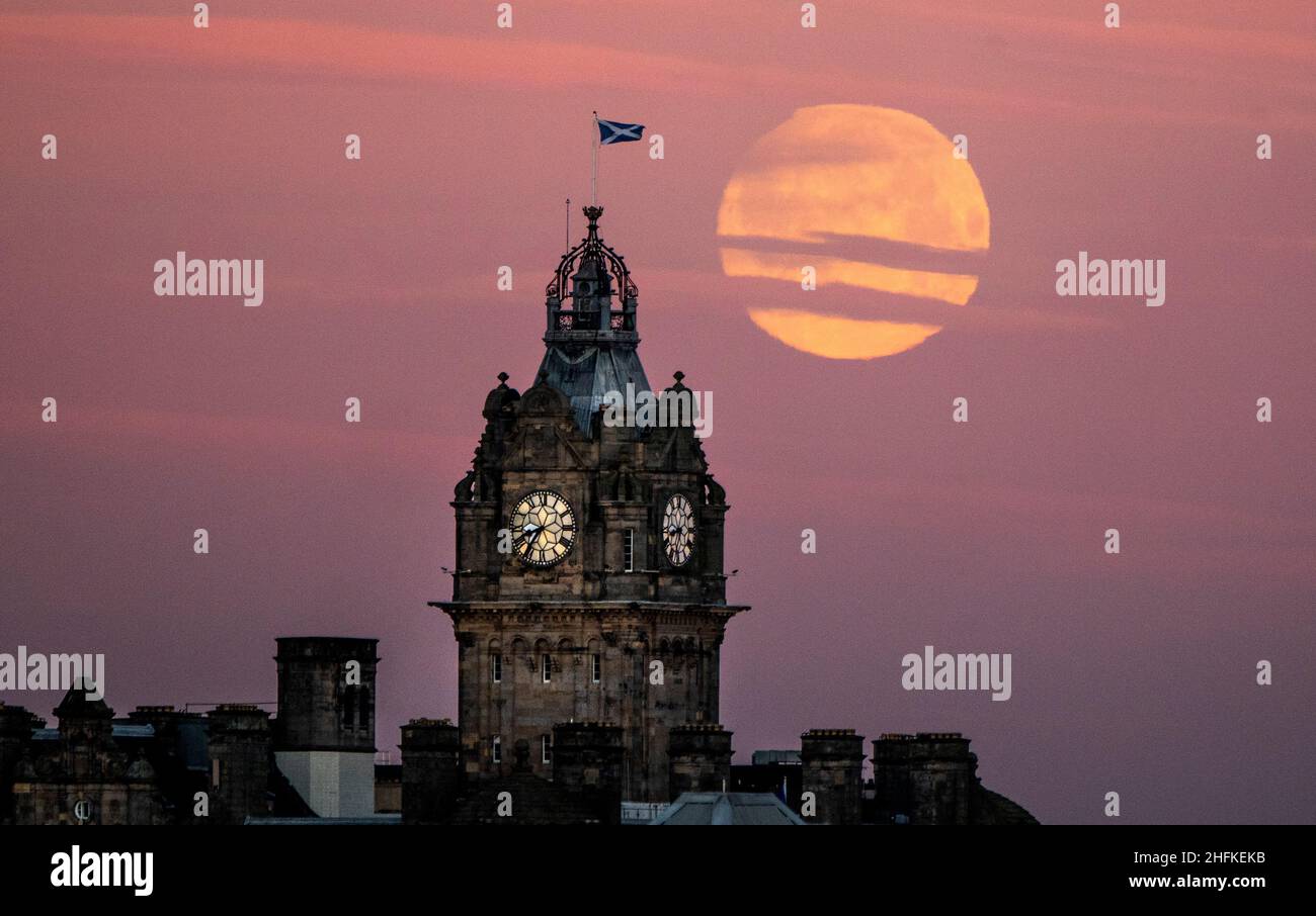 The moon sets behind the Balmoral Clock in Edinburgh. The first full ...