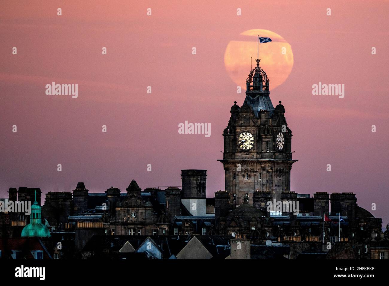 The moon sets behind the Balmoral Clock in Edinburgh. The first full ...